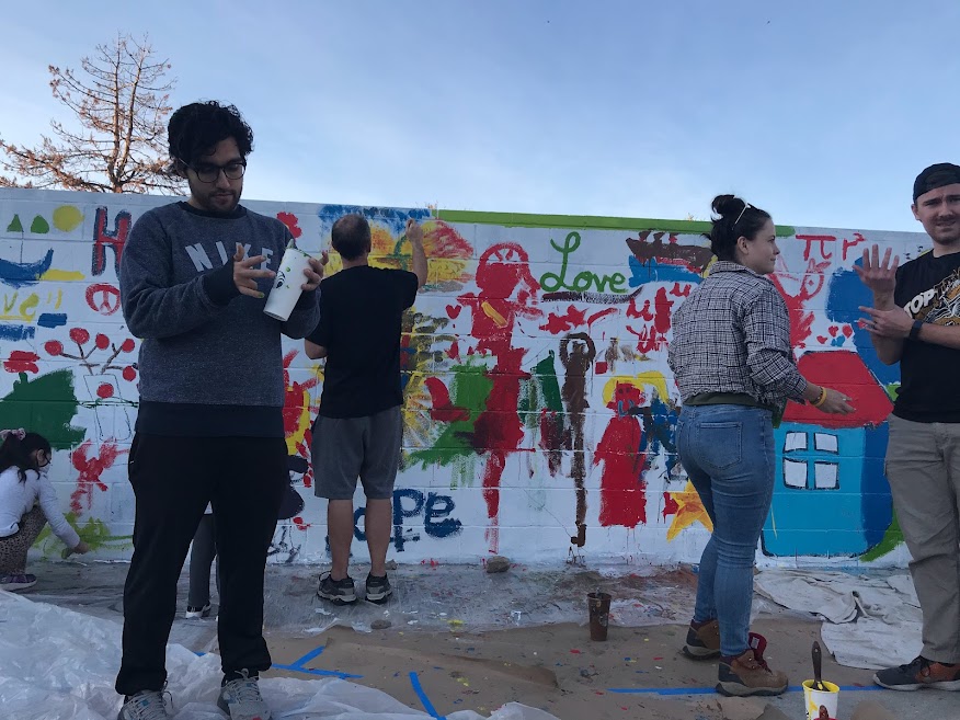 Artists brighten up neighborhood through colorful mural, with kids ...